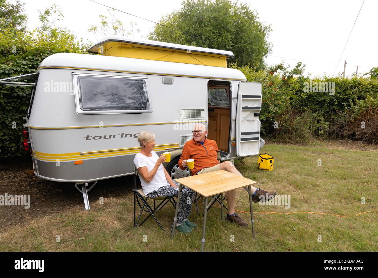 Caravan holiday UK; A mature retired senior couple sitting outside ...