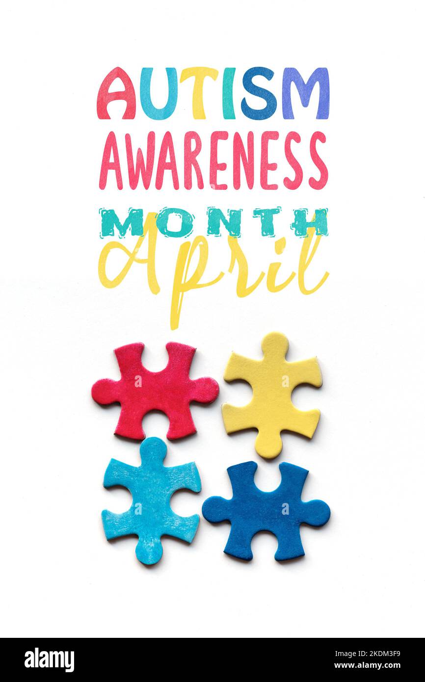 Text Autism Awareness Month, April. Close-up on four puzzle pieces ...
