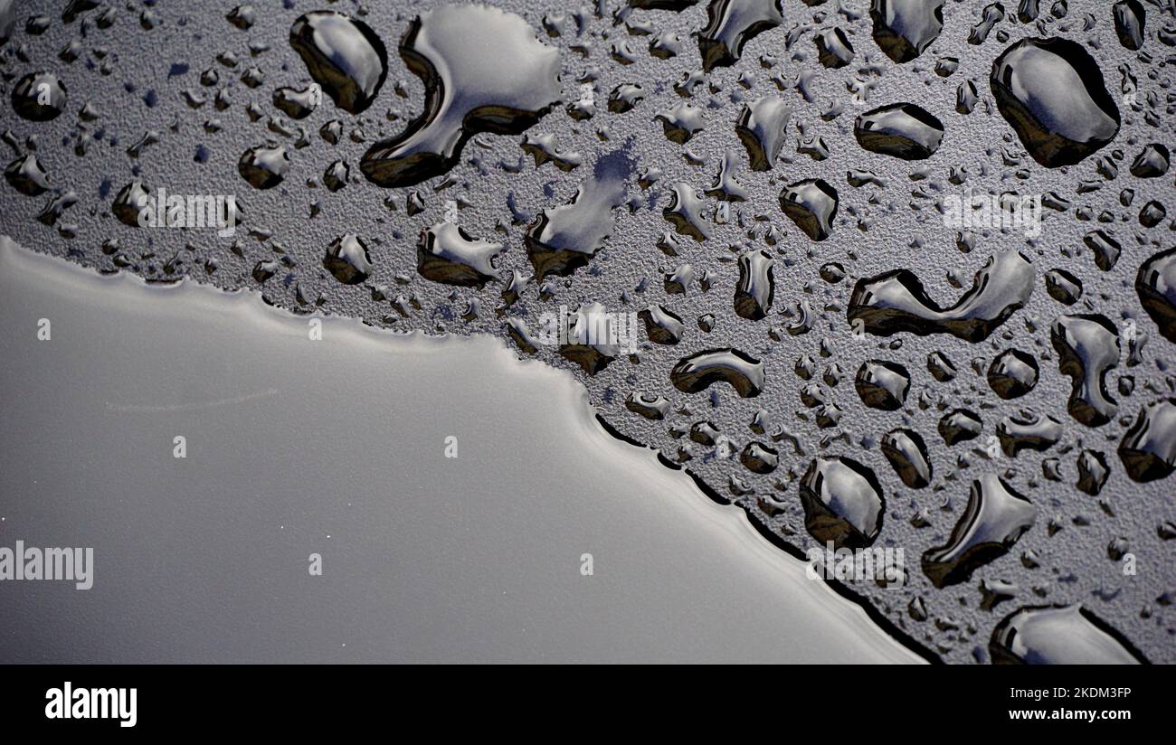 water drops on a gray plastic surface, horizontal, with narrow depth of ...