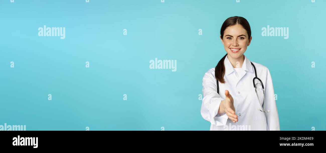 Smiling professional woman doctor, therapist extending hand, handshake ...