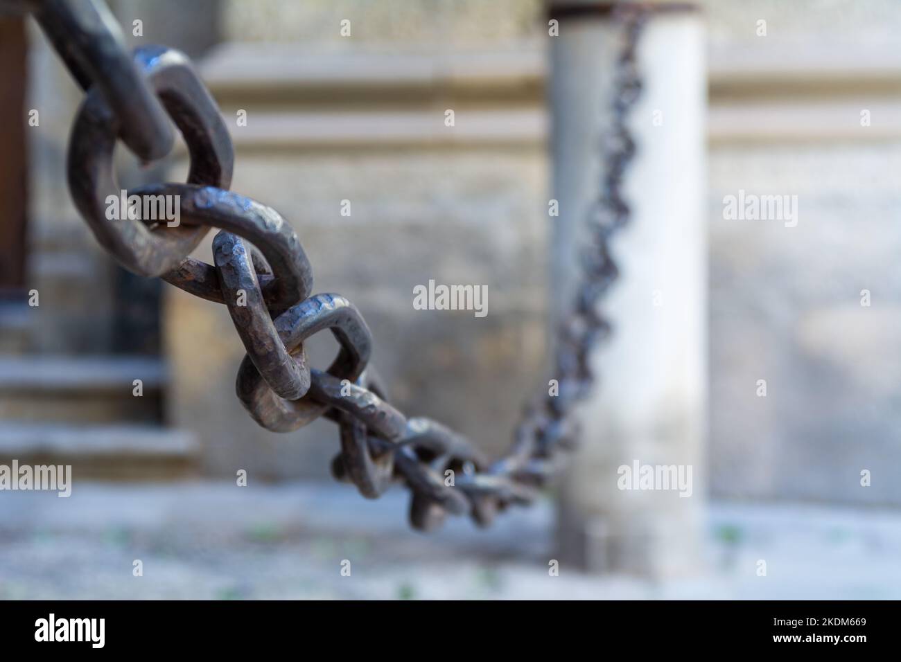 Old metal chain in front of a building with a defocused background ...