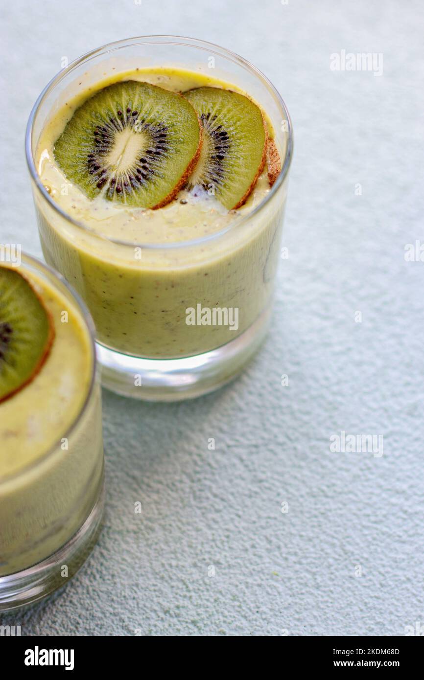 kiwi smoothie in a glass on blue background, blurred background Stock ...