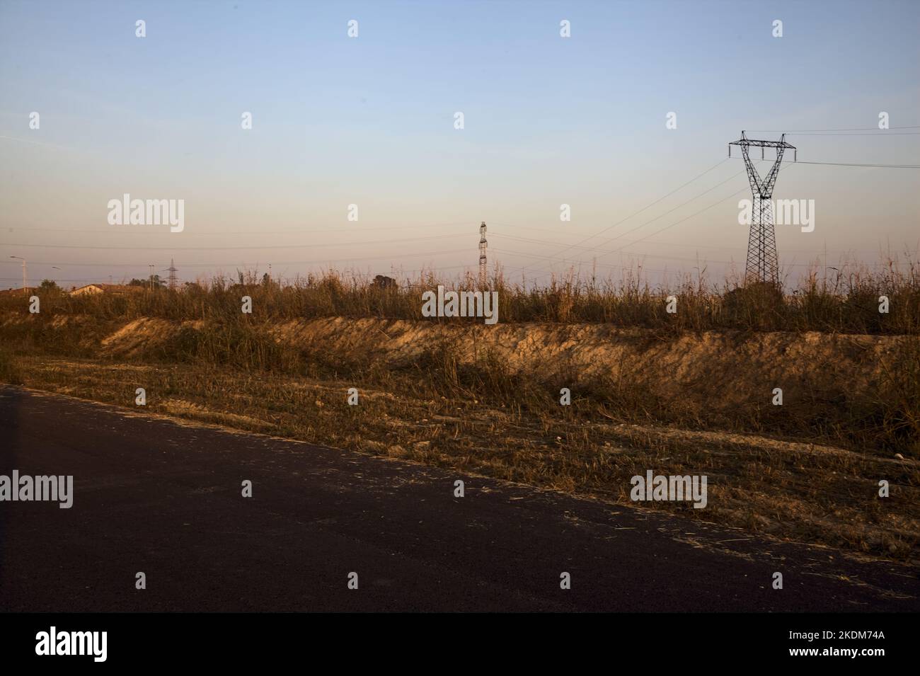 Electricity pylon in a field behind an embankment at the edge of a ...