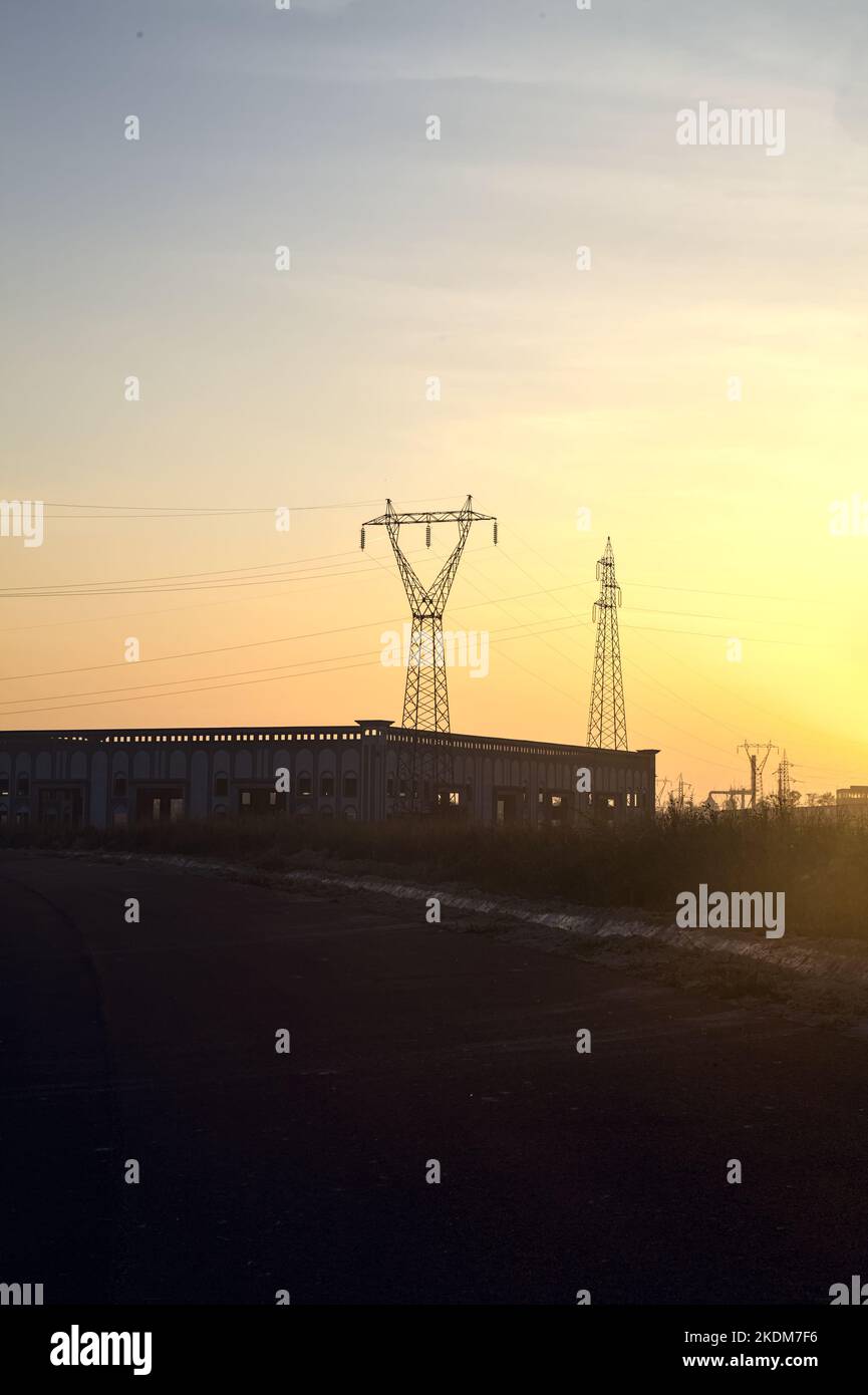 Empty road with abandoned warehouses and pylons at sunset Stock Photo ...