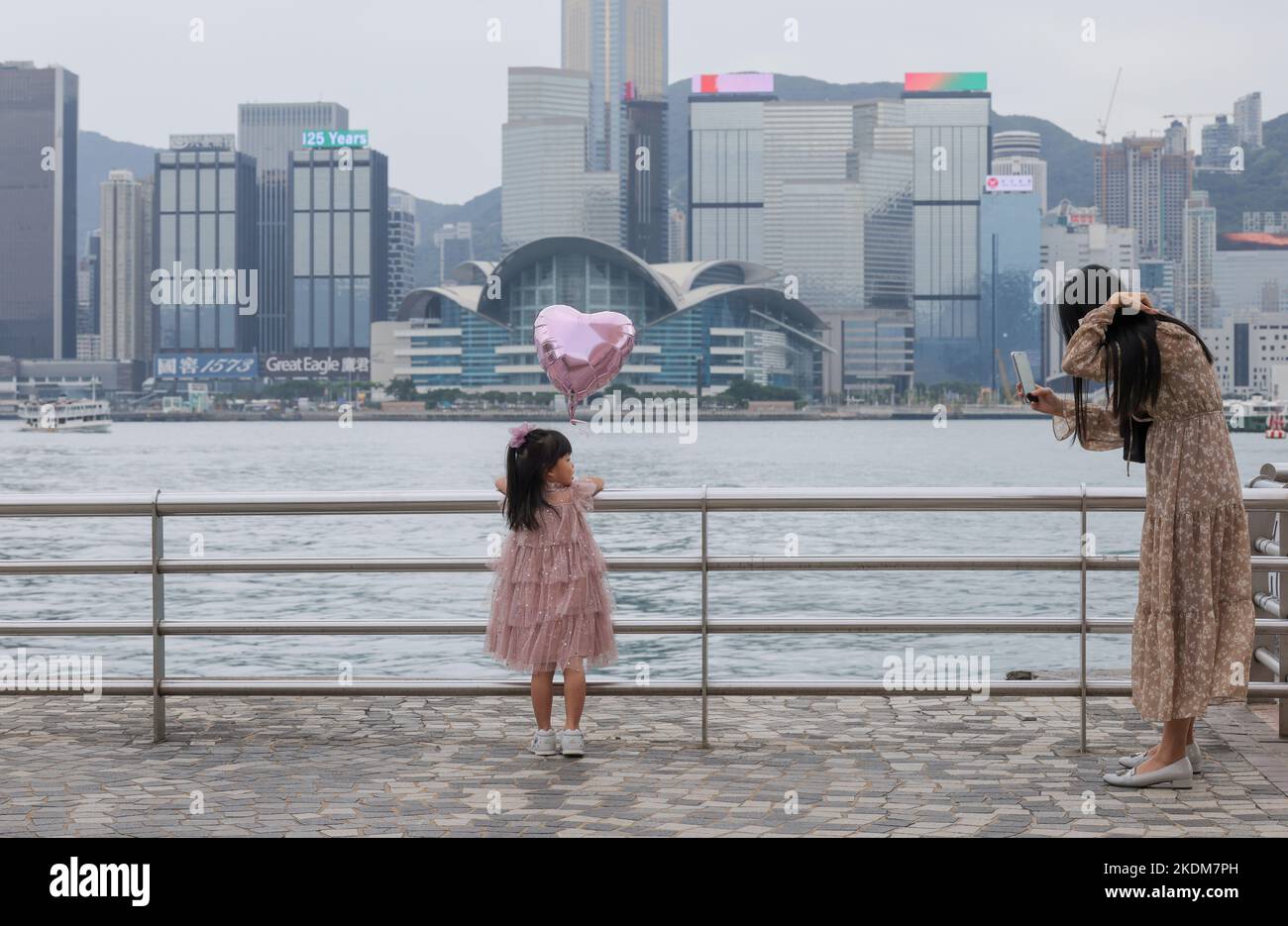 A little girl pose a photo at the waterfront of Victoria Harbour in ...
