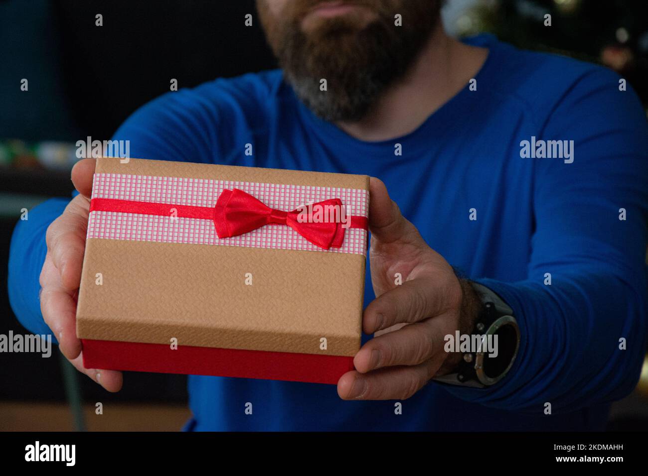 gift giving man hand holding a gift box in a gesture of giving ...