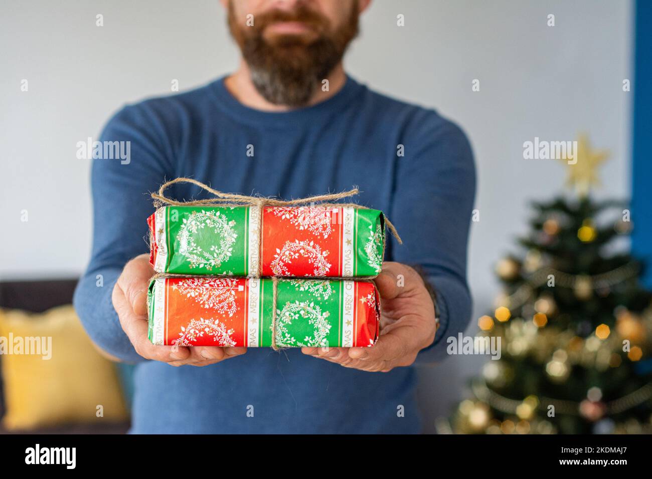 gift giving man hand holding a gift box in a gesture of giving ...