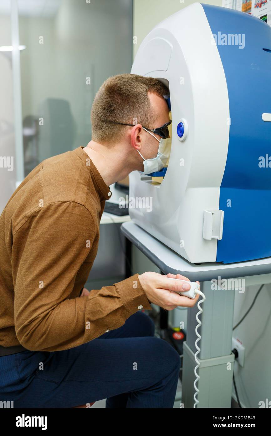 Professional medical equipment scanning the patient's eyes. The device ...