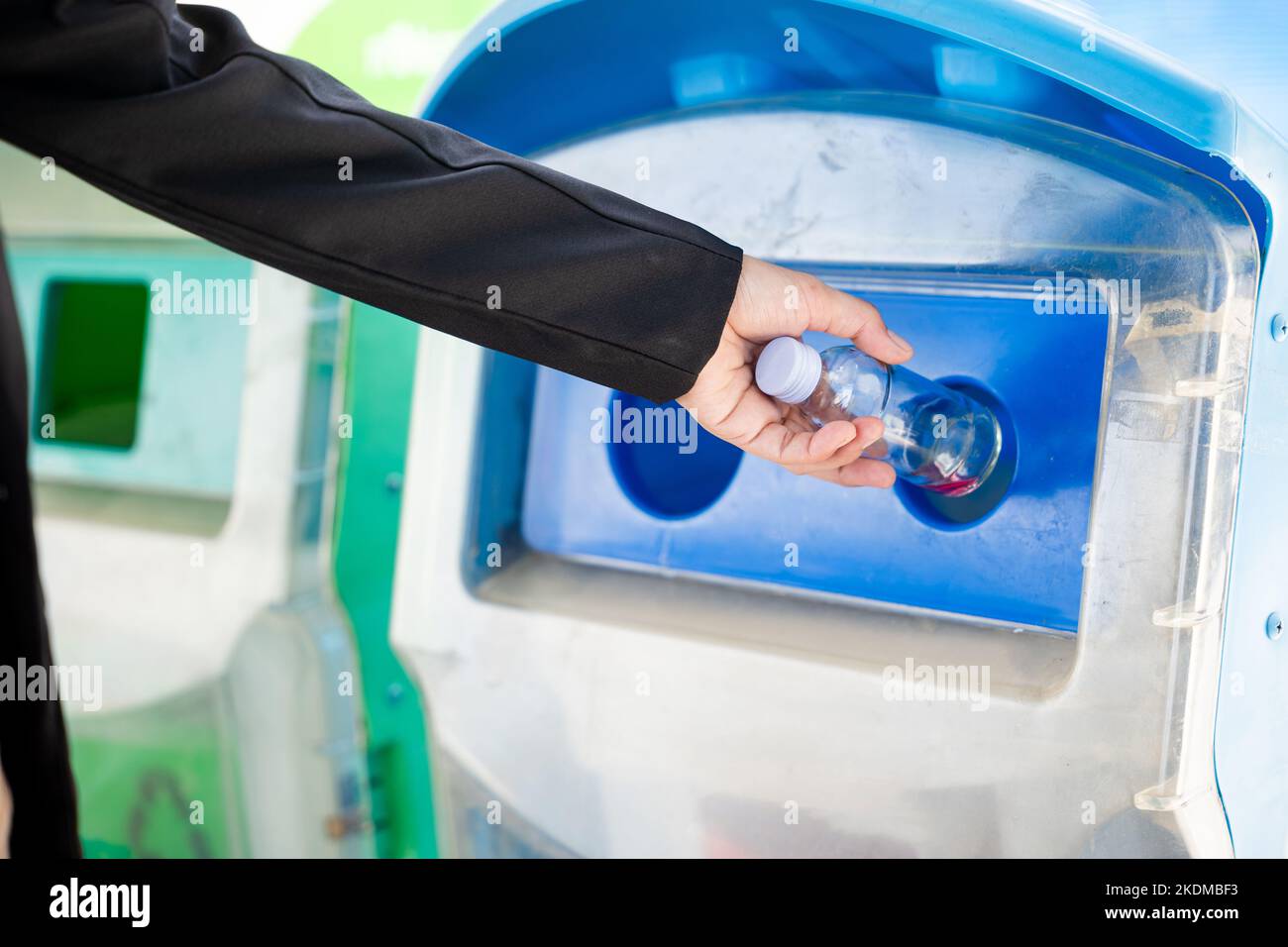 Business woman throwing empty glass bottle water into recycle garbage ...