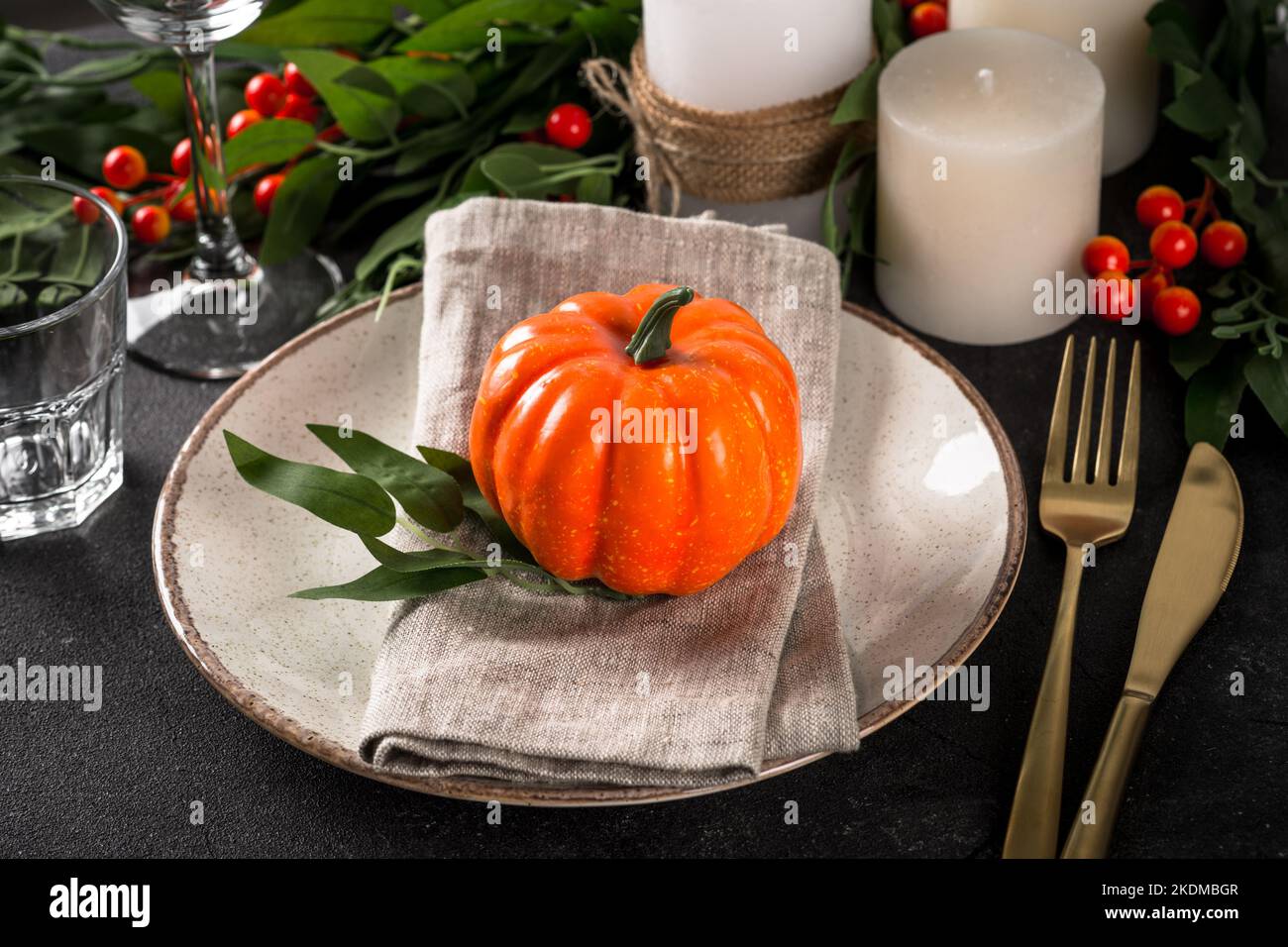 Autumn table setting with plate, pumpkin and candles Stock Photo - Alamy
