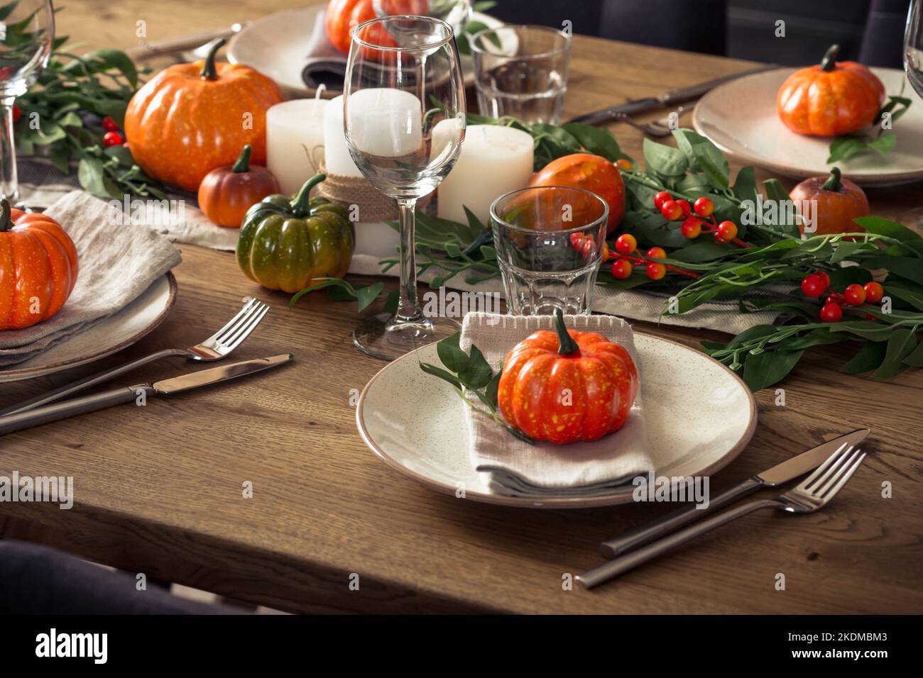 Autumn table setting with plate, pumpkin and candles Stock Photo - Alamy