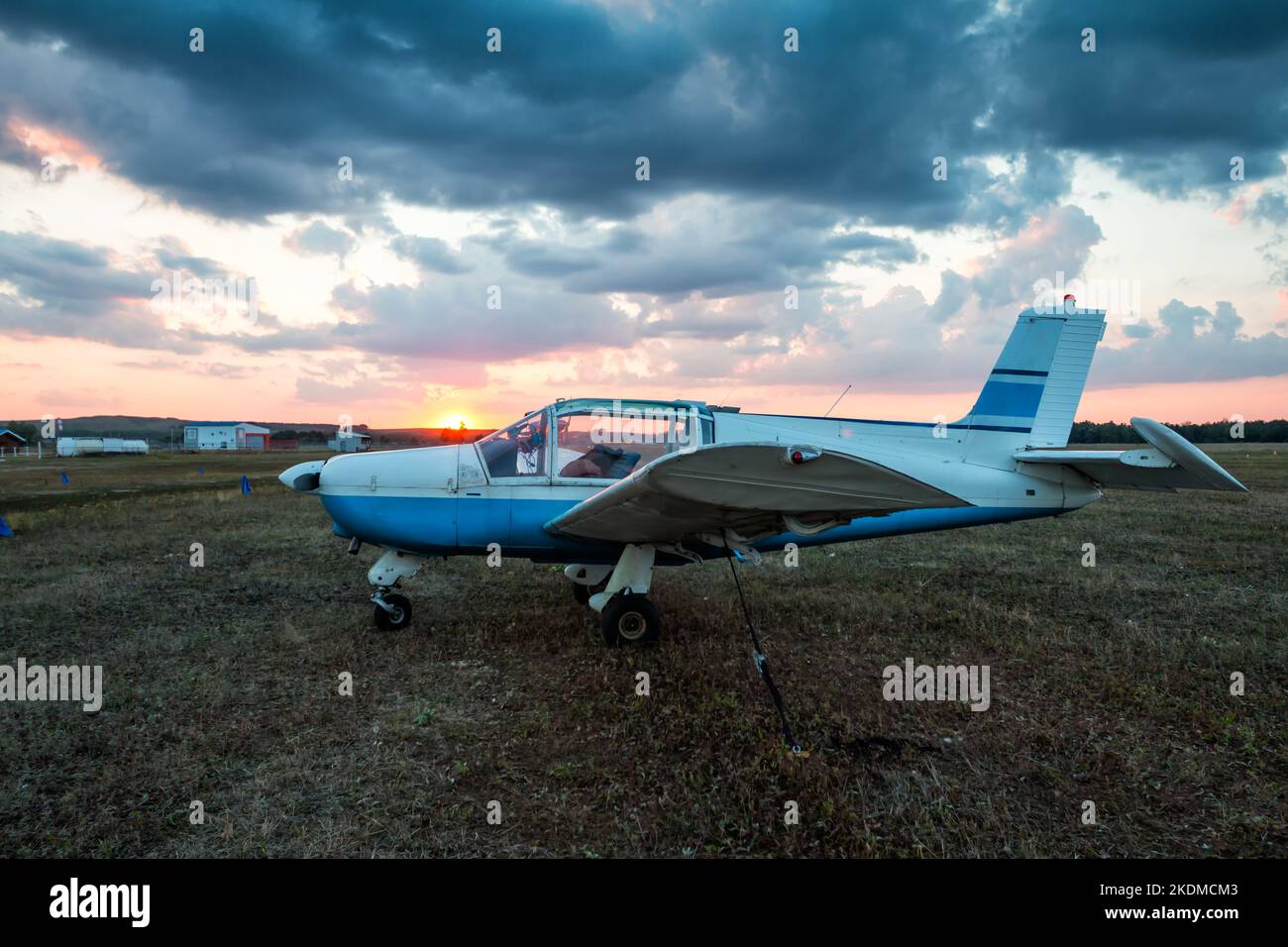 Small private aircraft parked at the airfield at picturesque sunset ...