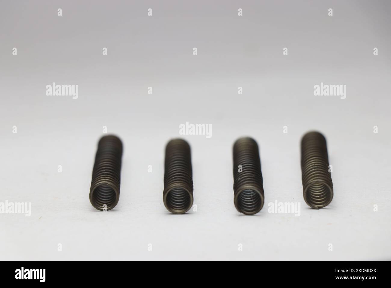 Four steel compression coil springs with same surface finish with a ...
