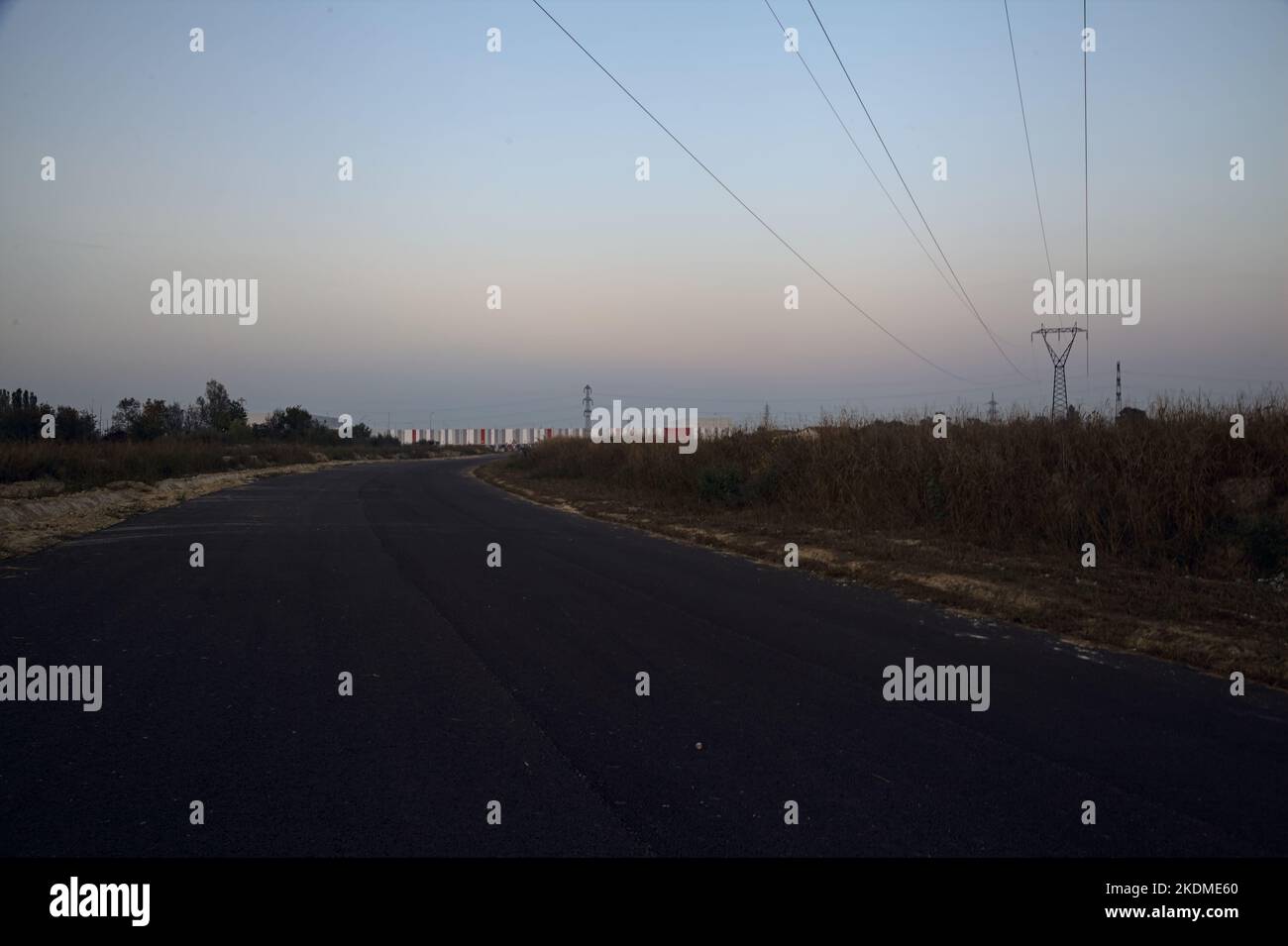 Electricity pylon in a field behind an embankment at the edge of a ...