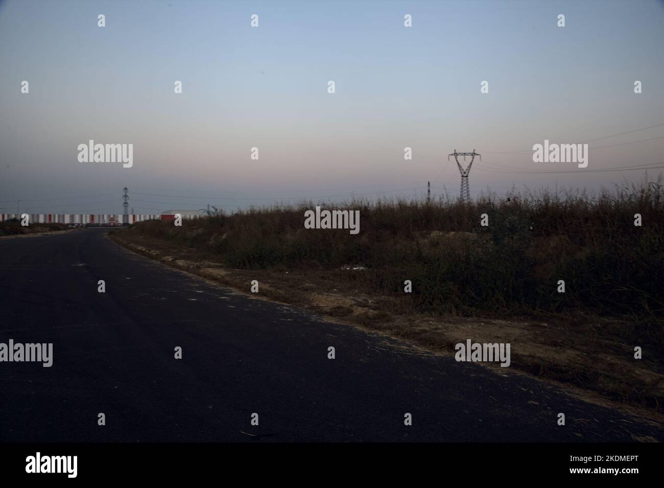 Electricity pylon in a field behind an embankment at the edge of a ...