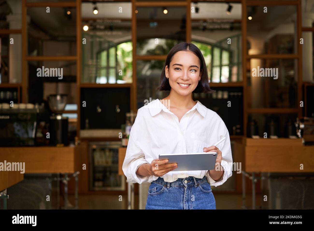 Portrait of smiling asian cafe staff, manager standing in front of ...