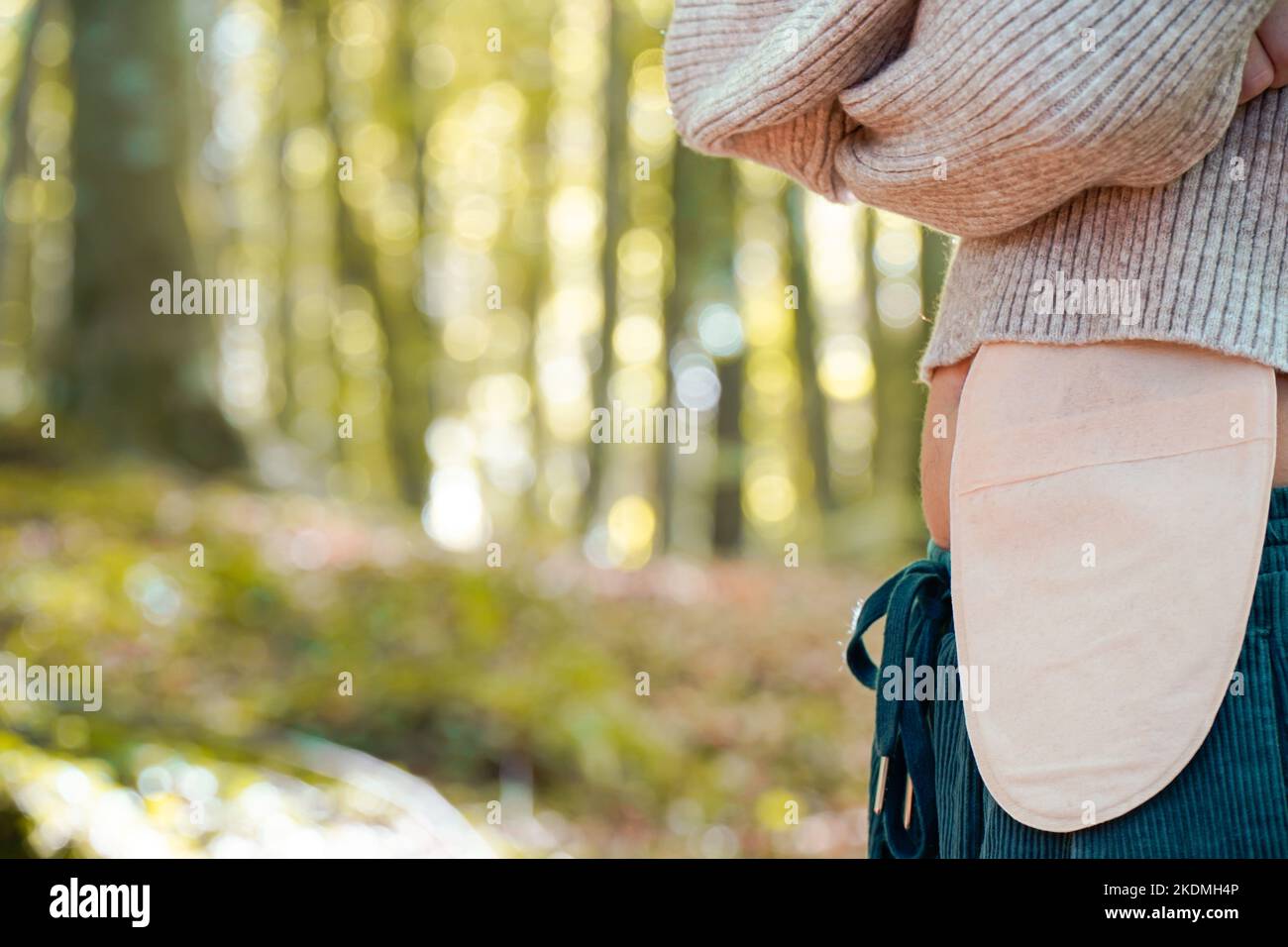 woman stomach with an ostomy bag in the forest with gold trees Stock ...