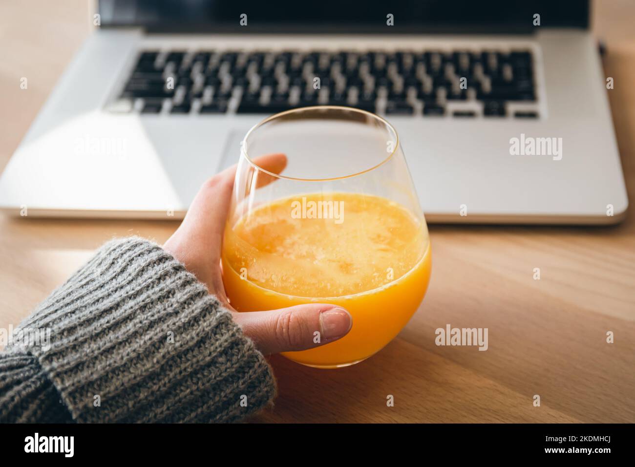 A glass of orange juice and a laptop, the concept of work and study ...