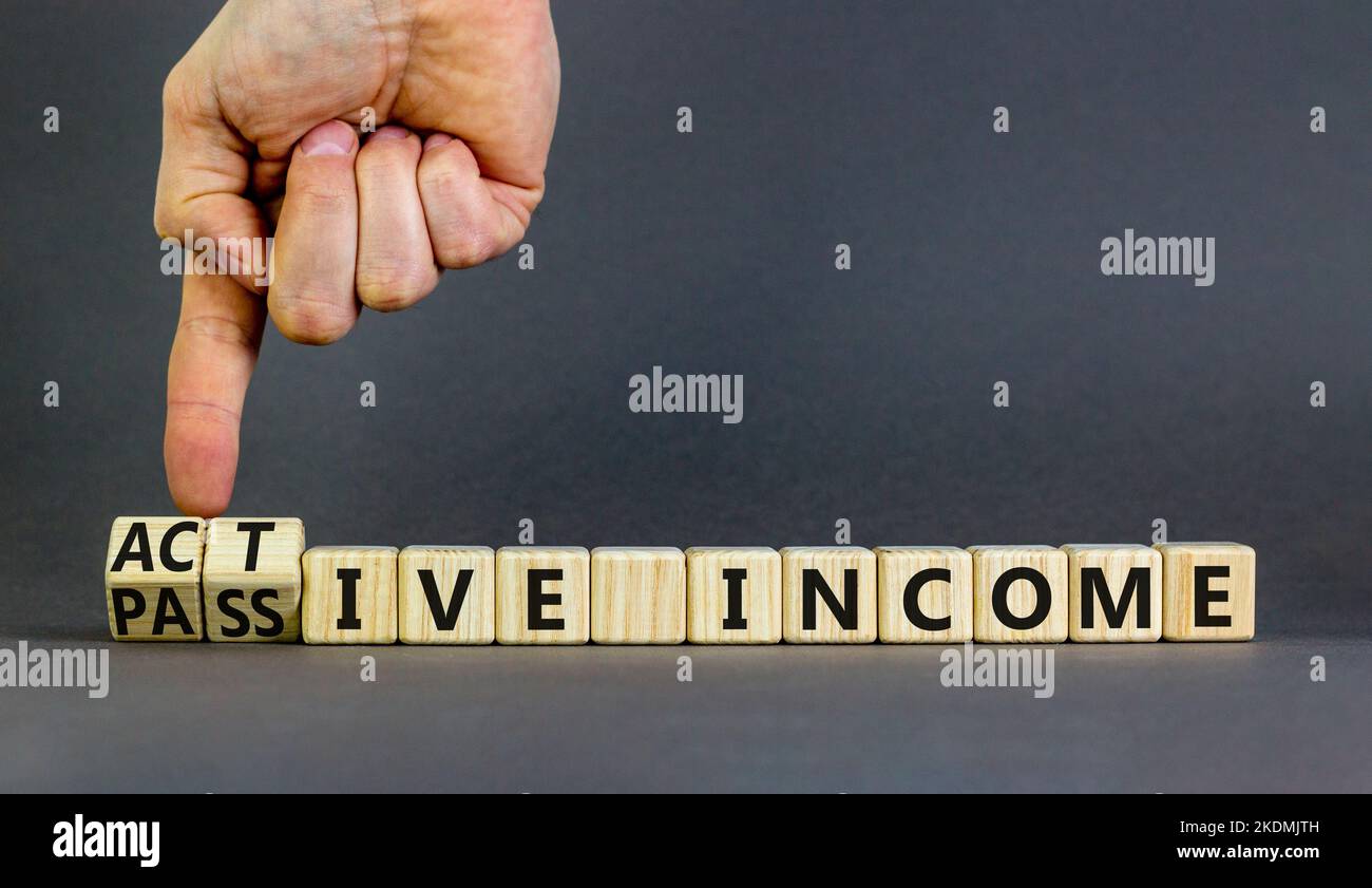 Passive or active income symbol. Businessman turns wooden cubes and ...