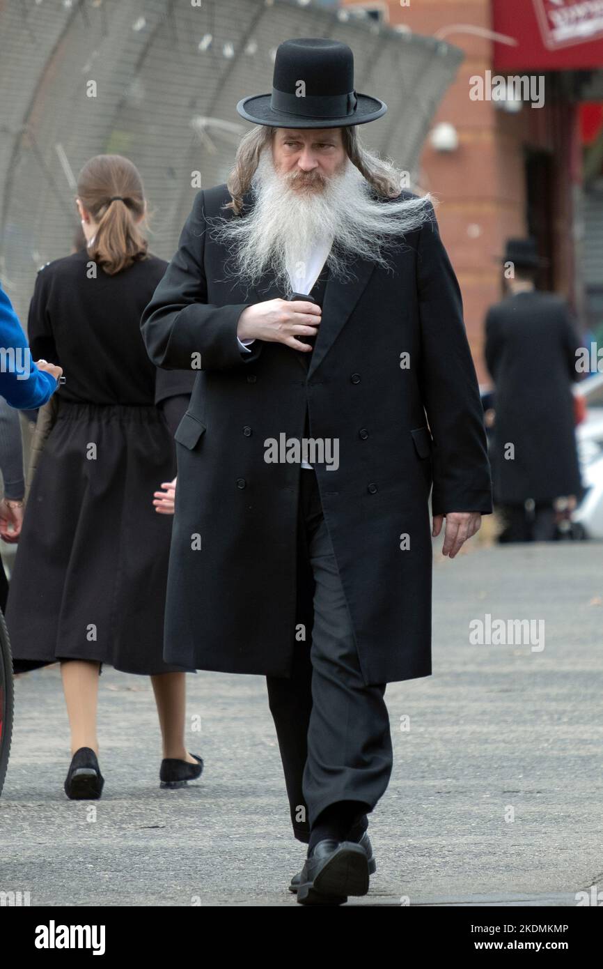 A Hasidic orthodox Jewish man walks on autumn day with his beard and ...