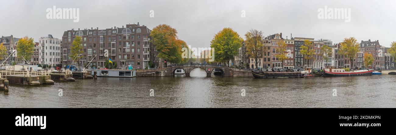 A panorama picture of the Amstel river and the building facades next to ...