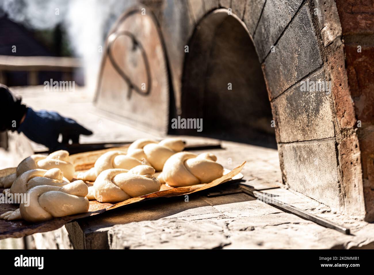 Baking buns in a traditional old oven outside Stock Photo - Alamy