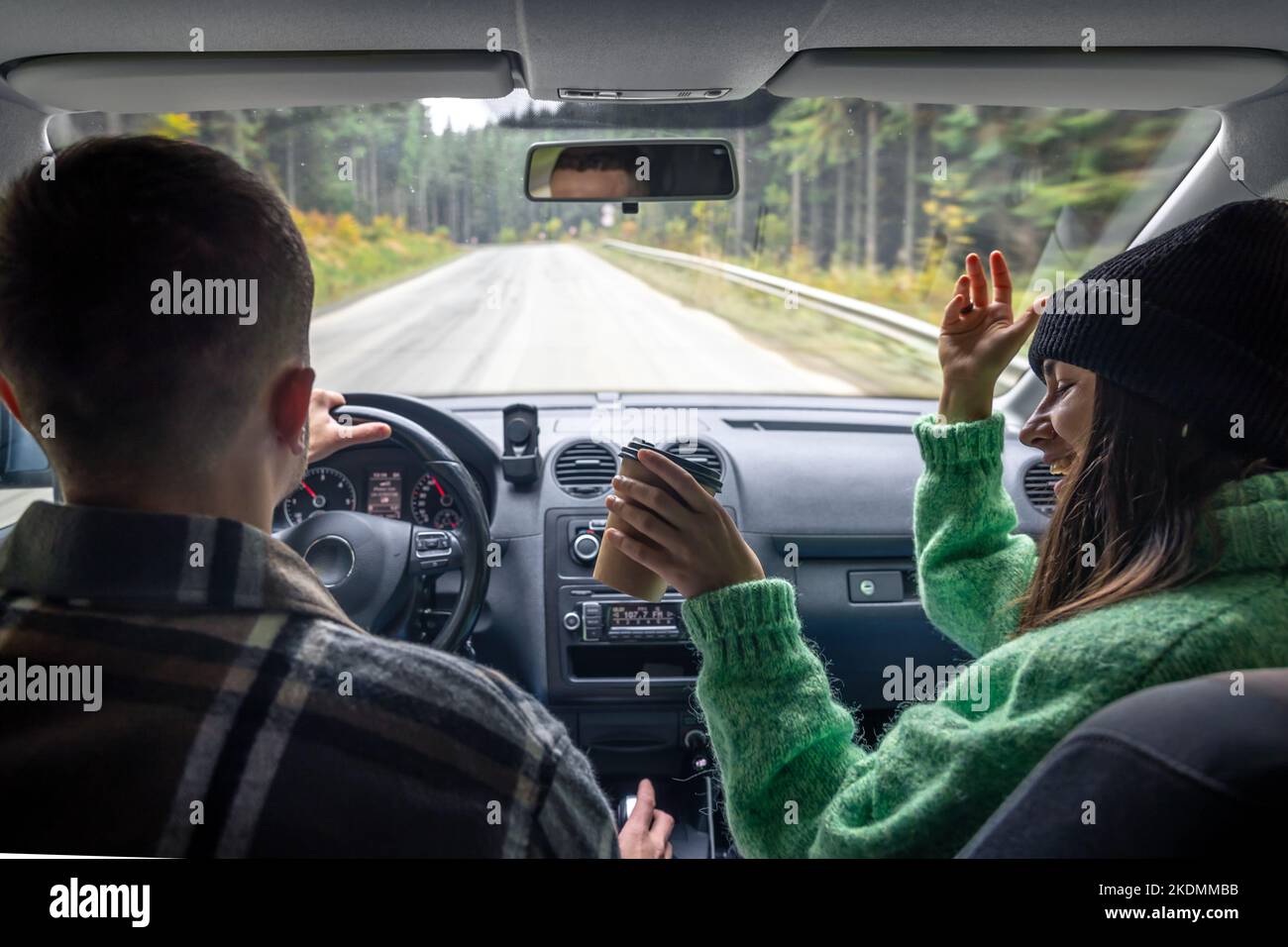 Rear back view from passenger seat of man and lady sitting inside car ...
