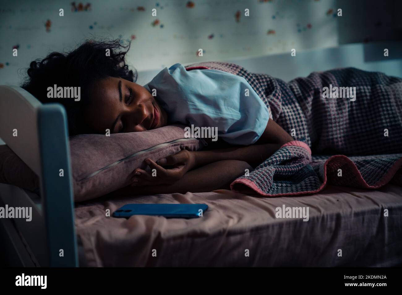 African teen girl sleeping near phone in her room at home Stock Photo ...