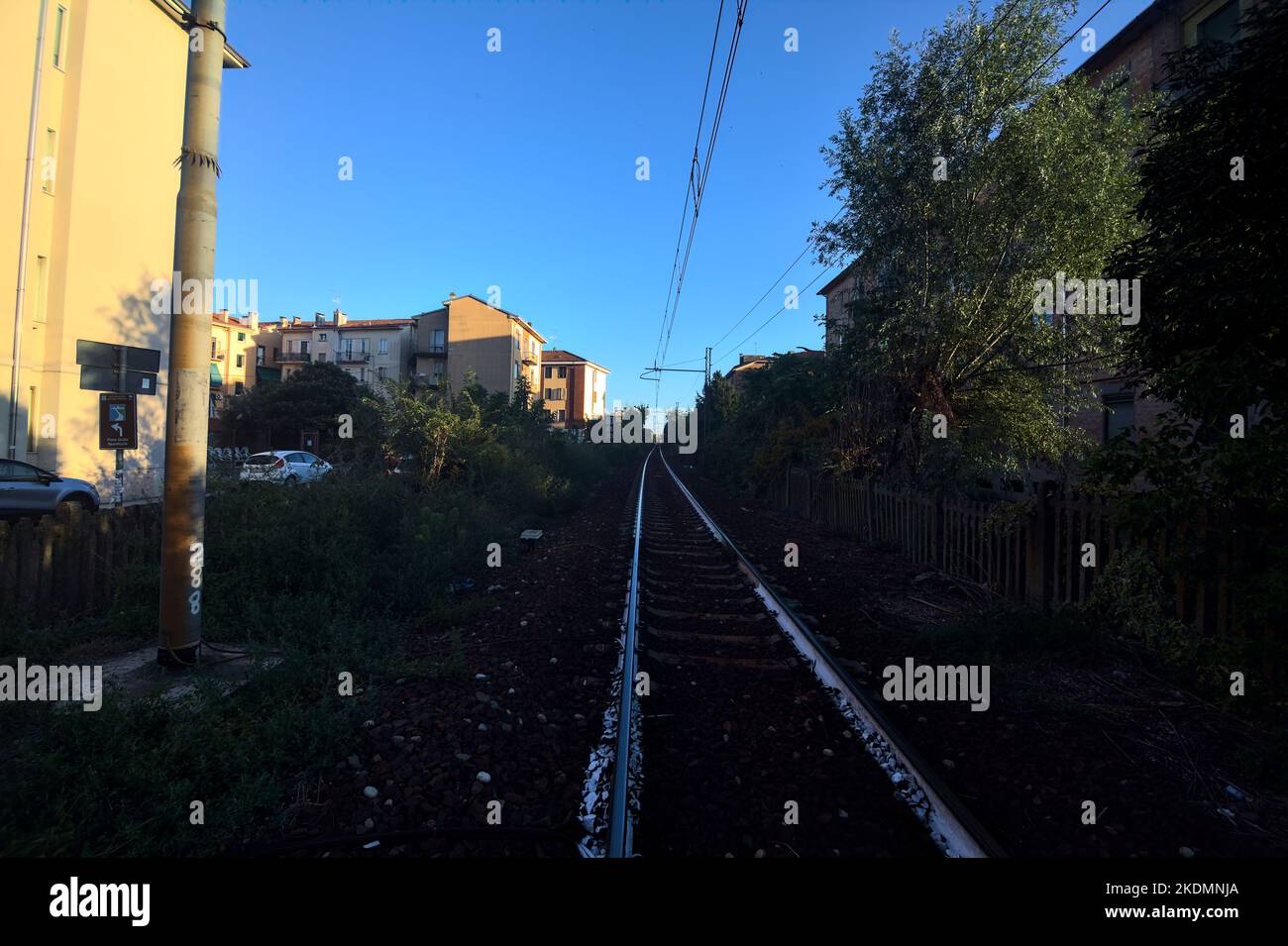 Railroad crossing with trees and buildings by its side at sunset Stock ...