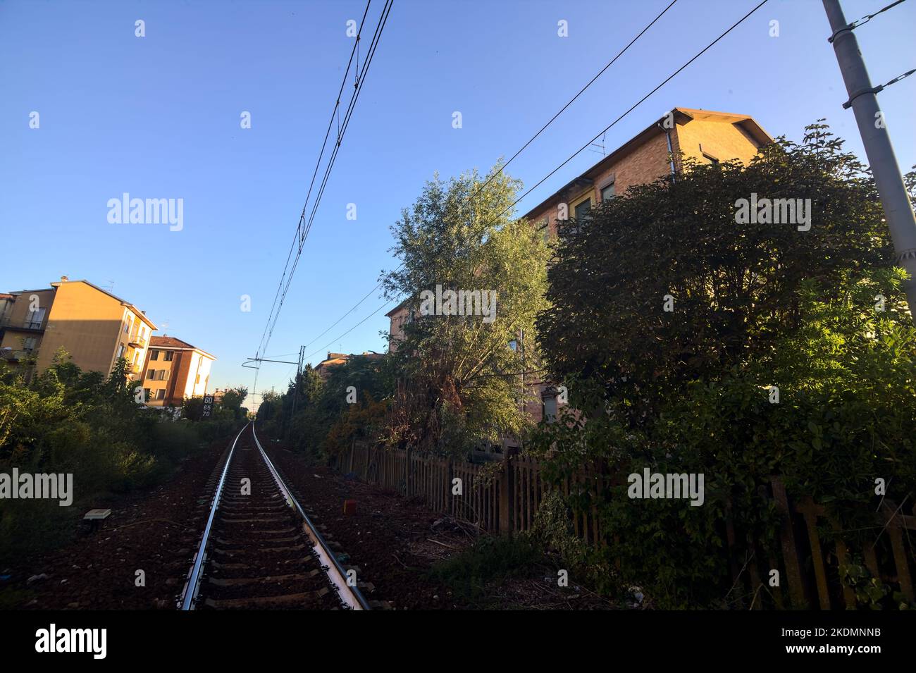 Railroad crossing with trees and buildings by its side at sunset Stock ...