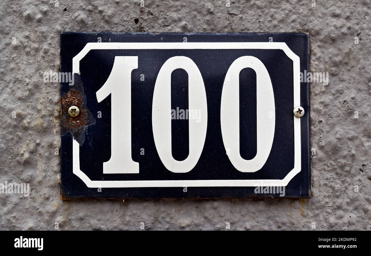 Street sign number 100 on a gray wall Stock Photo - Alamy