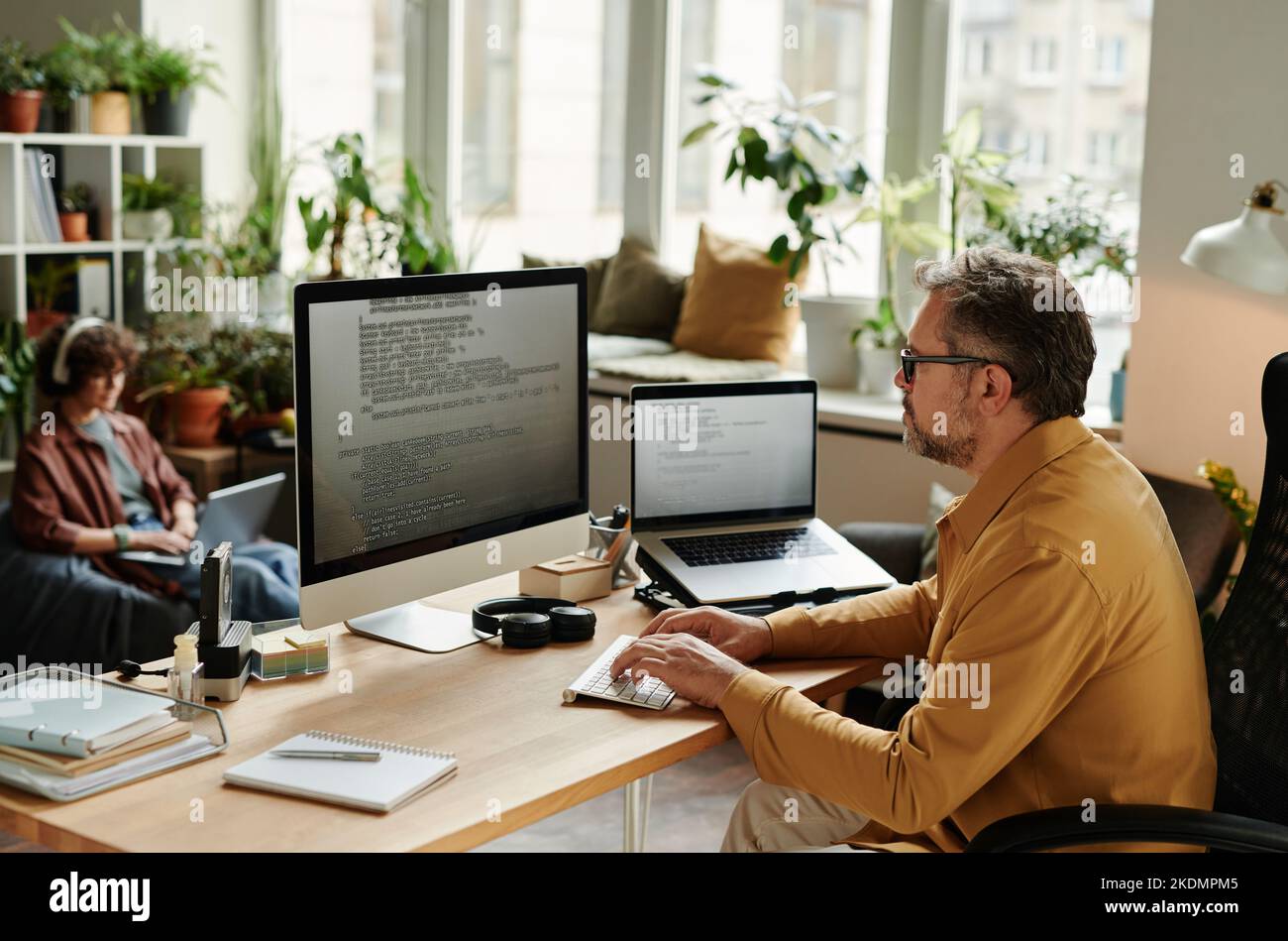 Serious businessman concentrating on decoding data while sitting by ...