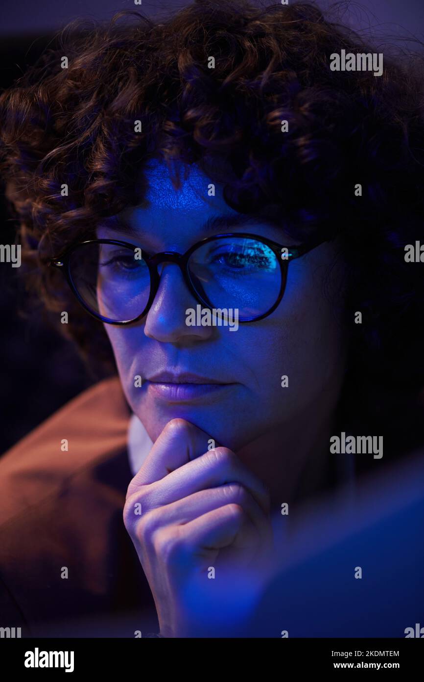 Young busineswoman with pensive facial expression sitting in front of ...