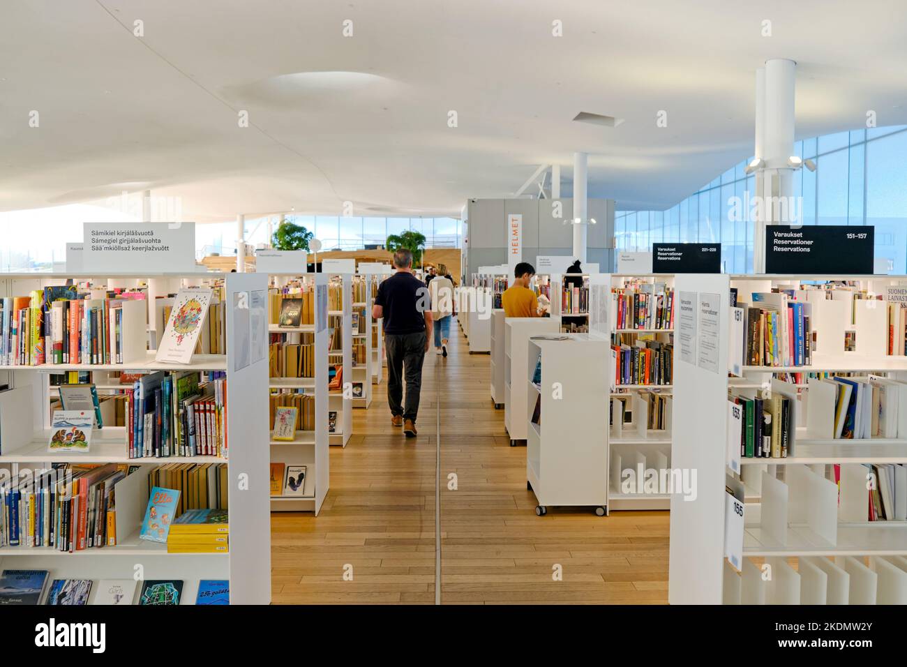 Modern library interior with book shelves and walking readers in ...