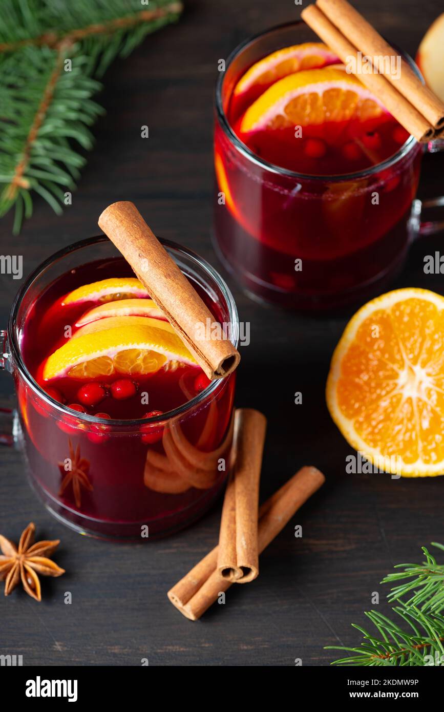 Two glasses with hot mulled wine with orange and spices on a wooden ...