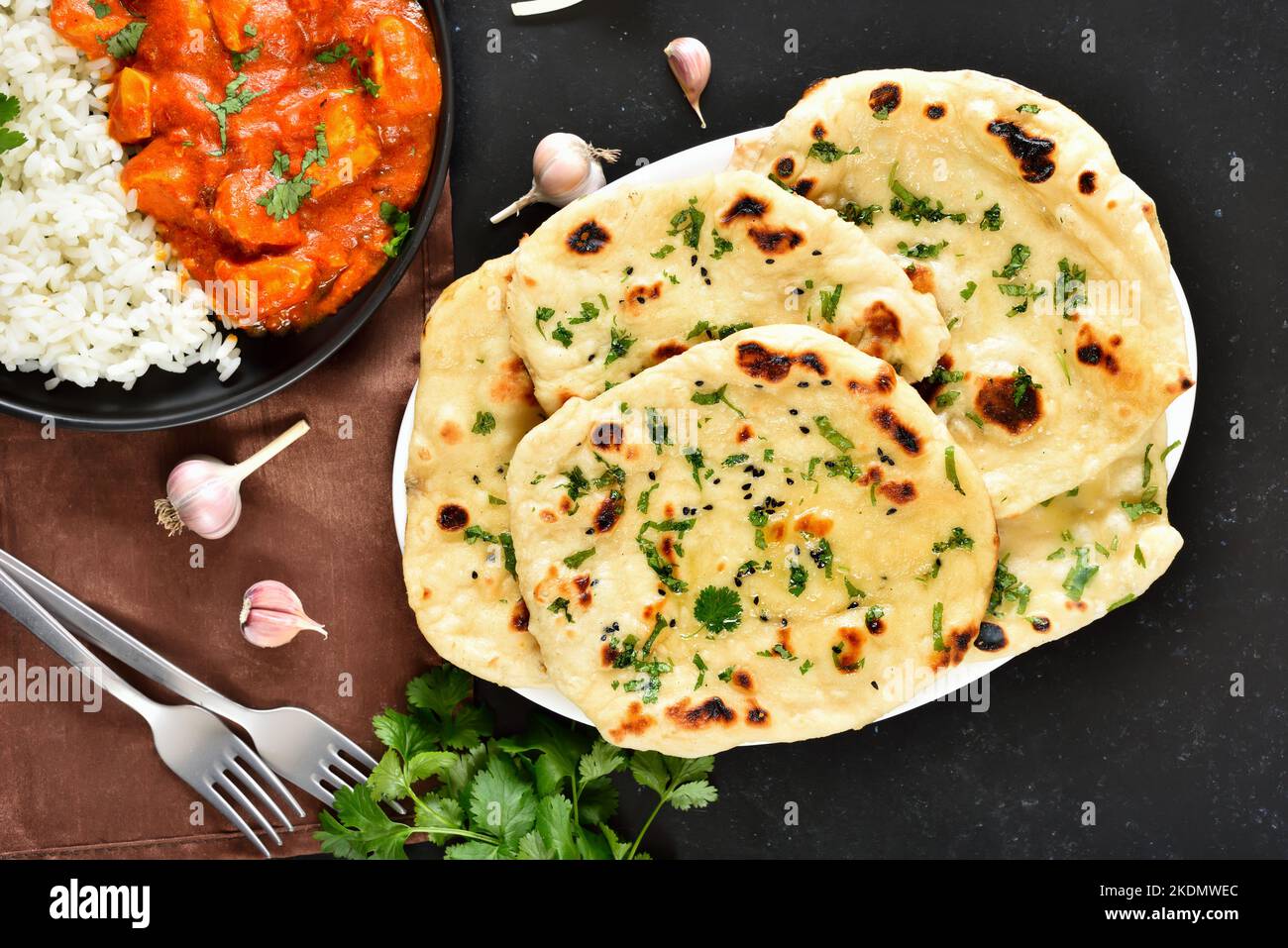Indian naan bread and chicken curry over dark stone background. Top ...