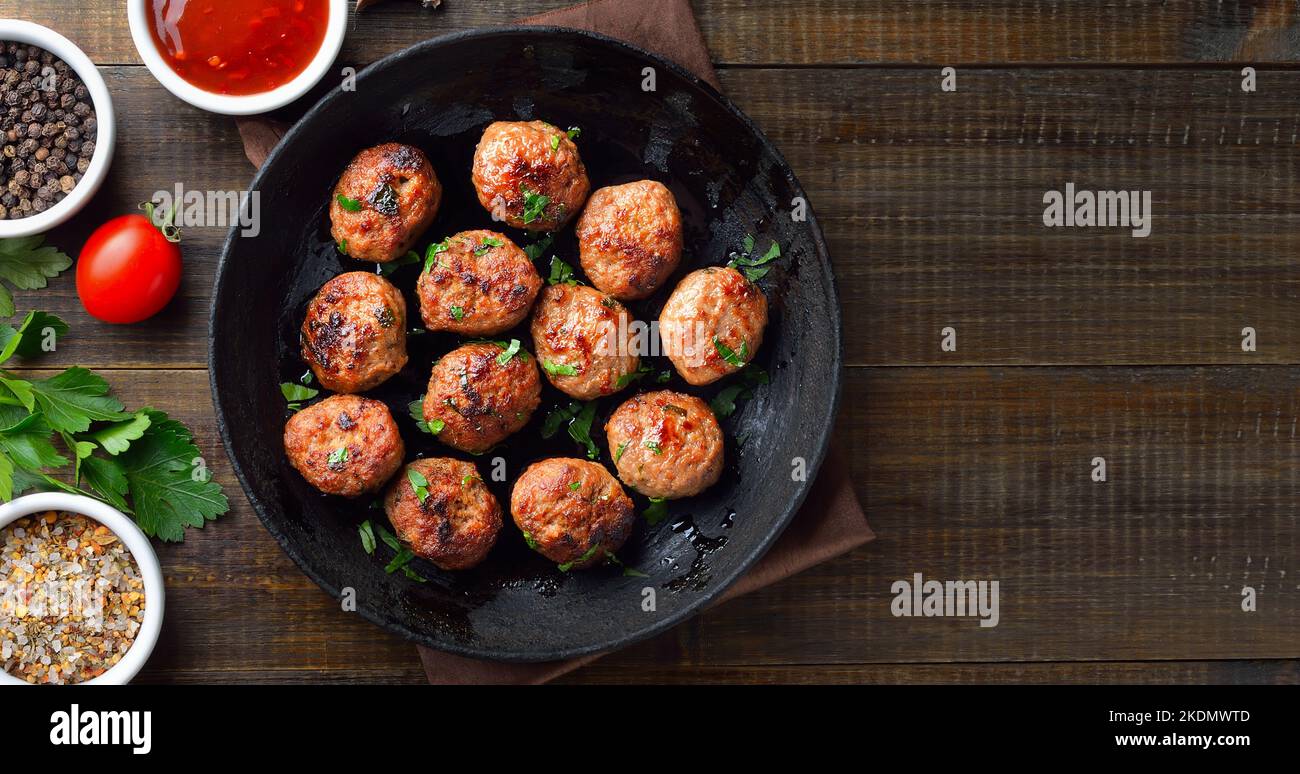 Roasted meatballs in frying pan over wooden background with copy space ...