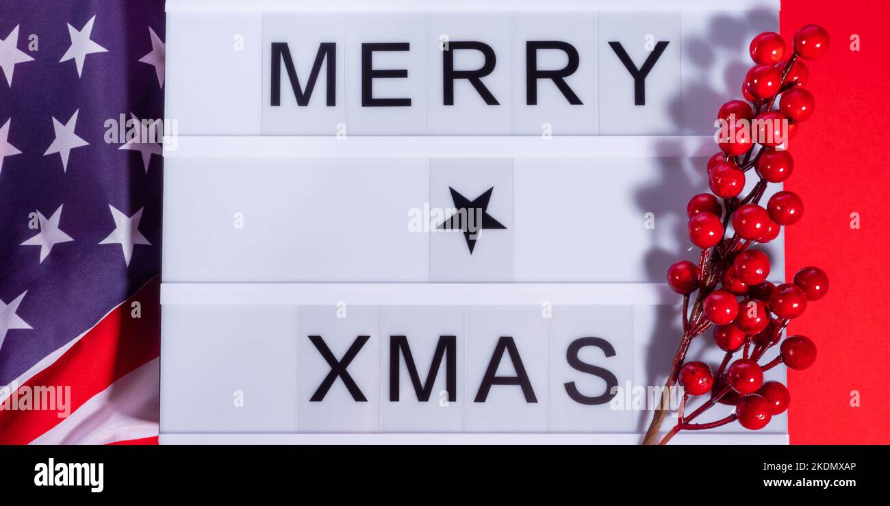 Merry Christmas greetings on lightbox on red with american flag Stock ...