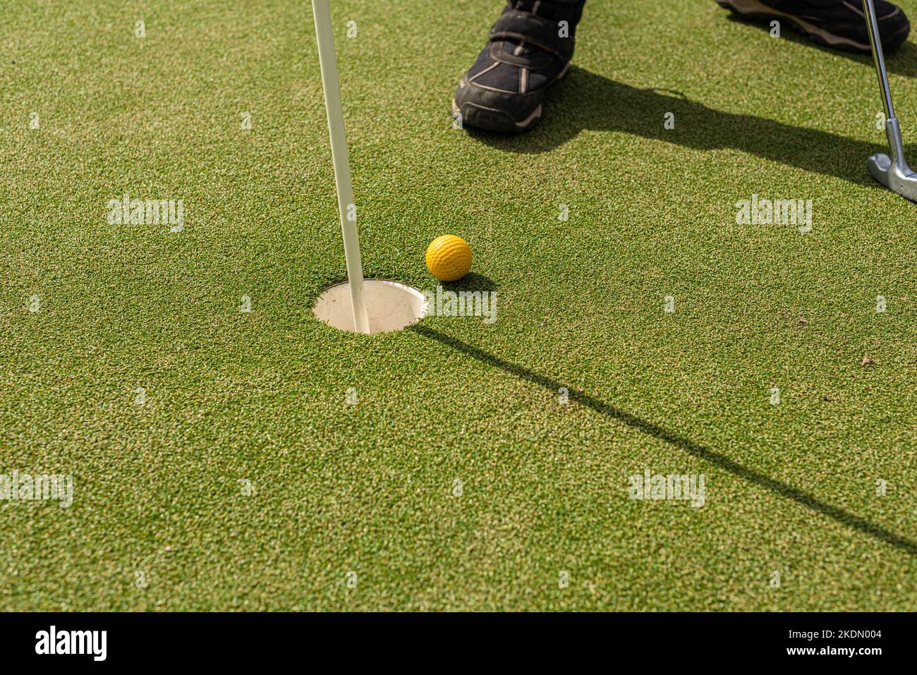 Pin, hole and ball of a minigolf course Stock Photo - Alamy
