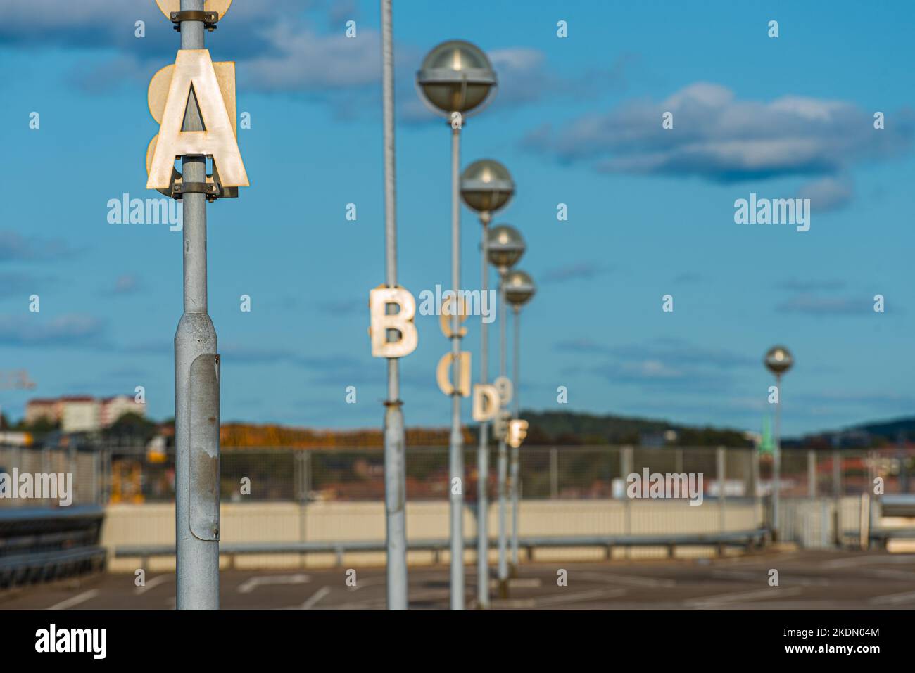 Letters on poles marking rows at a parking lot Stock Photo - Alamy