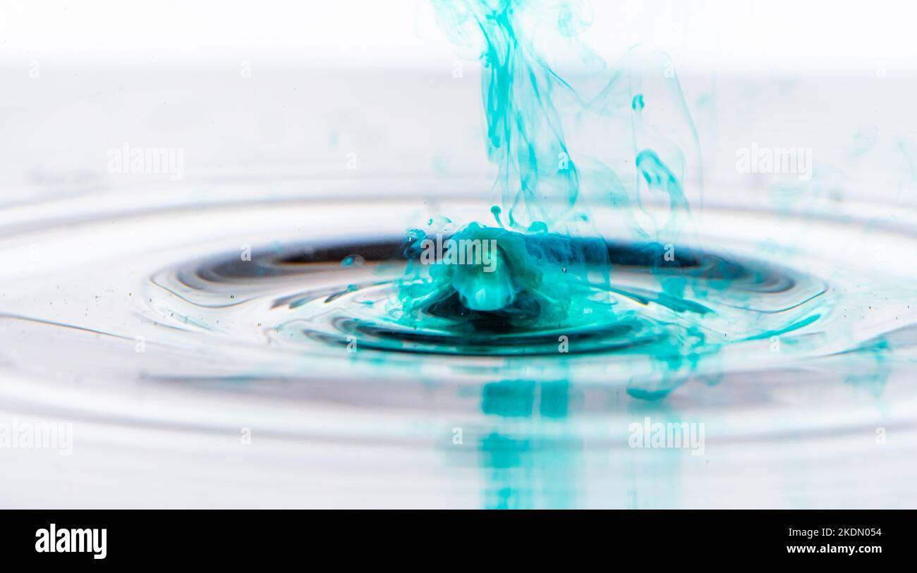Green colored water drop splashing in clear water Stock Photo - Alamy