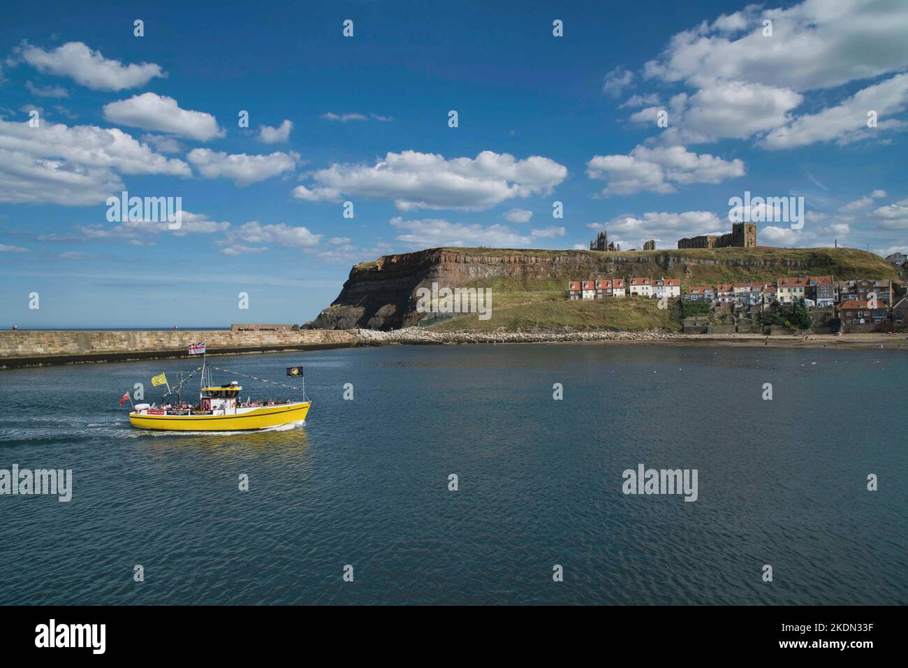 Pleasure boat entering harbour at Whitby, North Yorkshire with East ...