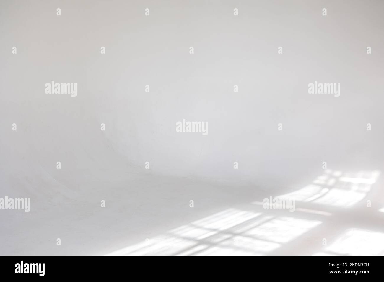 Clear white cyclorama. Light background with sun light and shadows ...