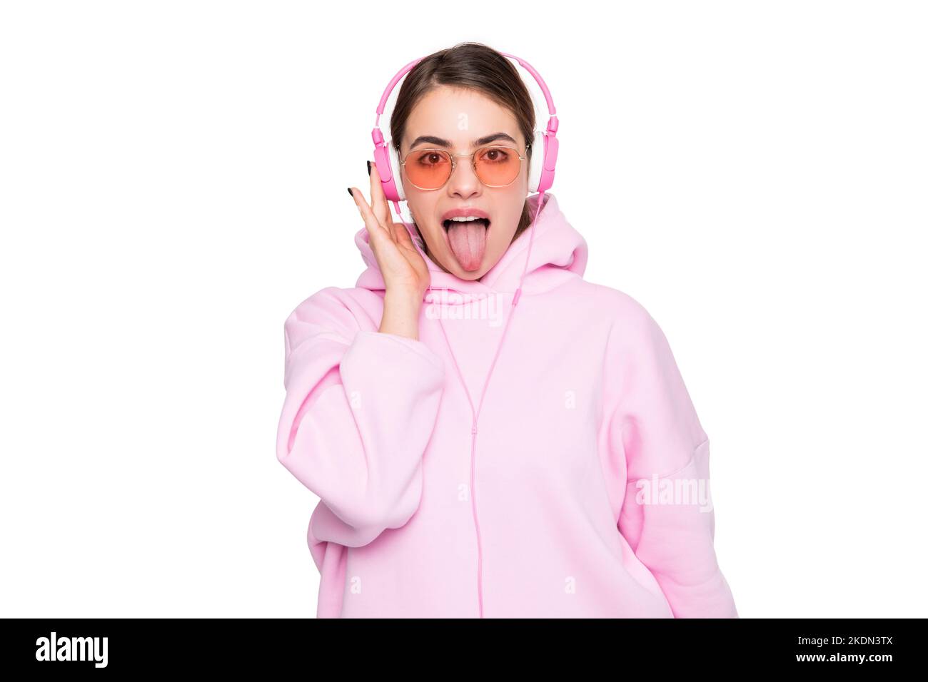Girl in pink hoodie and glasses listening to music in headphones ...