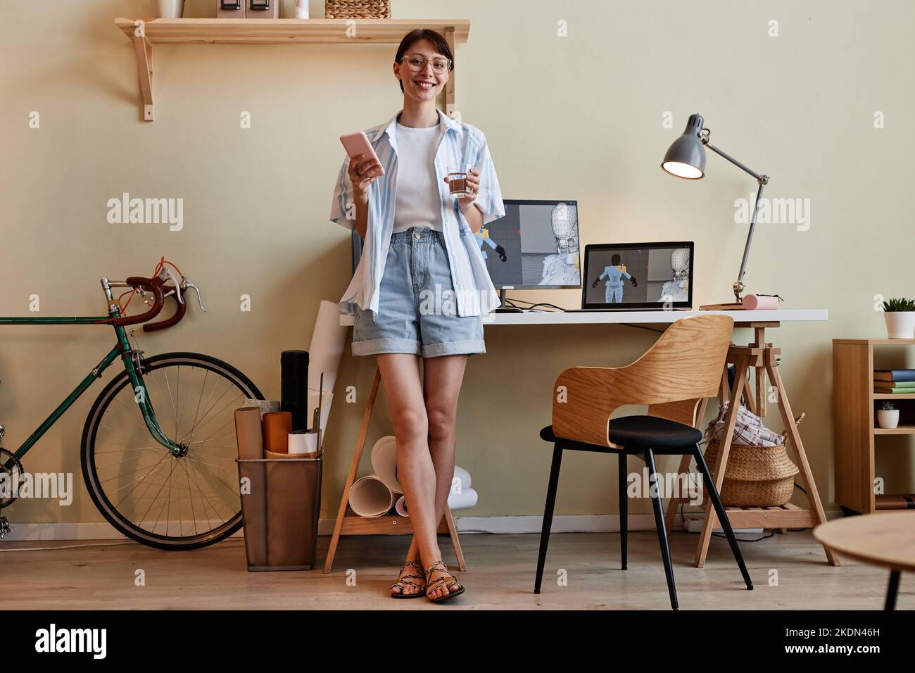 Full length portrait of creative young woman as 3D designer looking at ...