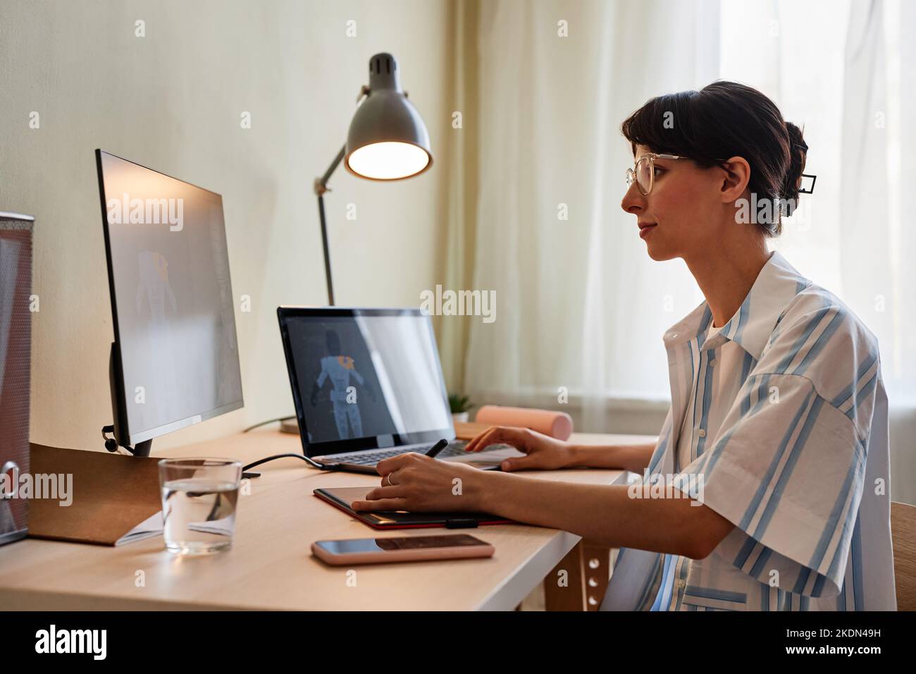 Side view portrait of female digital designer building 3D models and ...