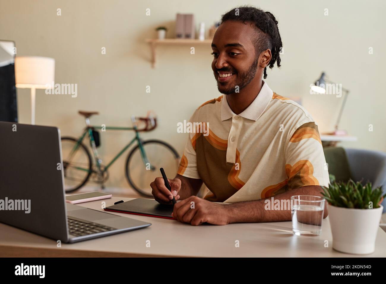 Portrait of smiling black man as digital artist or photographer using ...