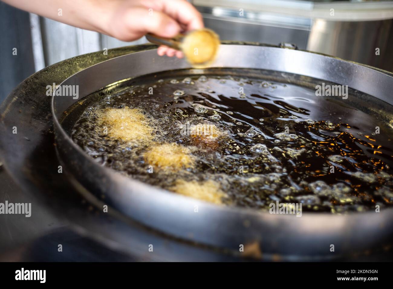 Hand with Tool Drops Golden Falafels to Fry in a Large Pan Filled with ...