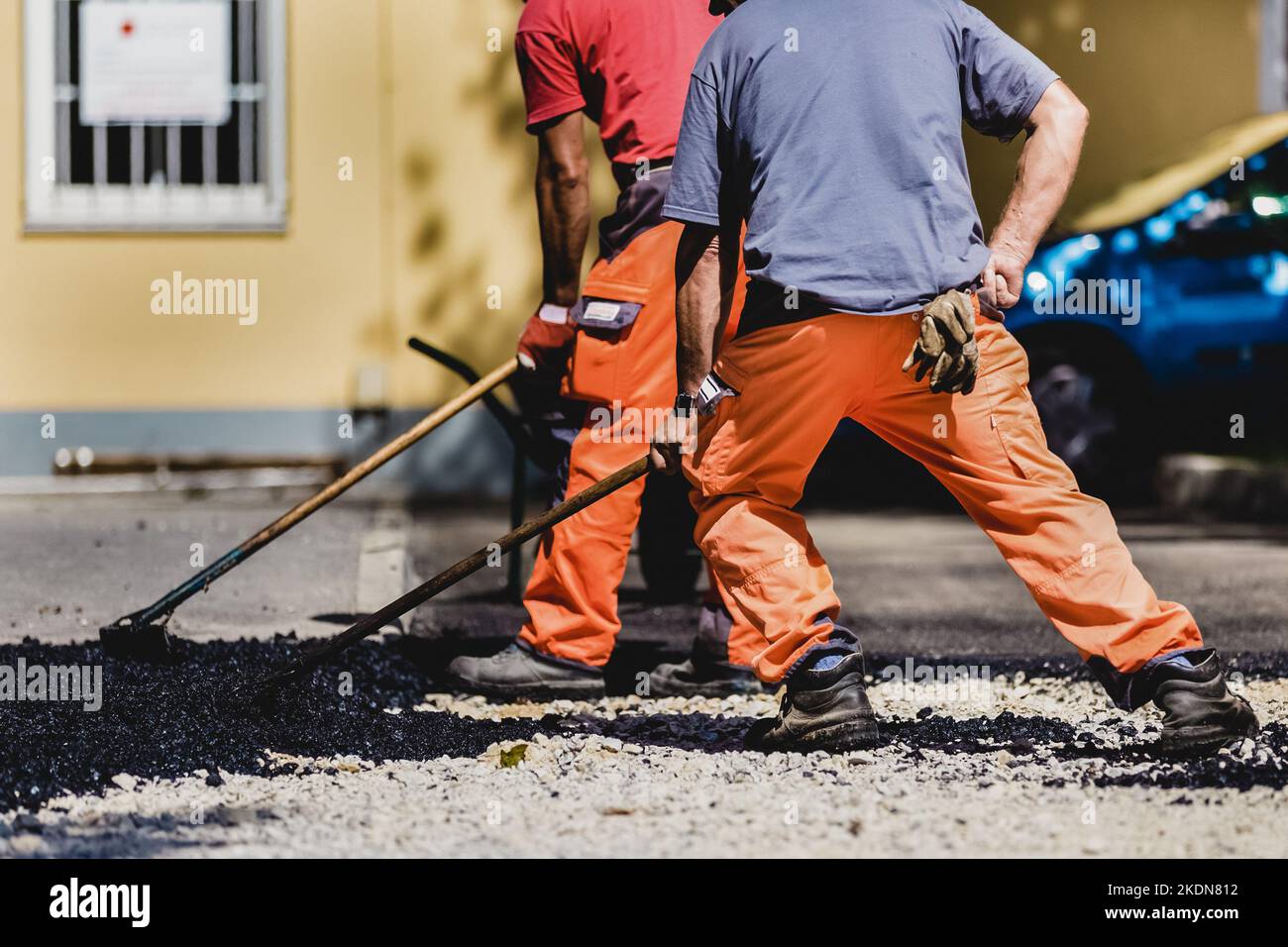 Construction workers during asphalting road works wearing coveralls ...