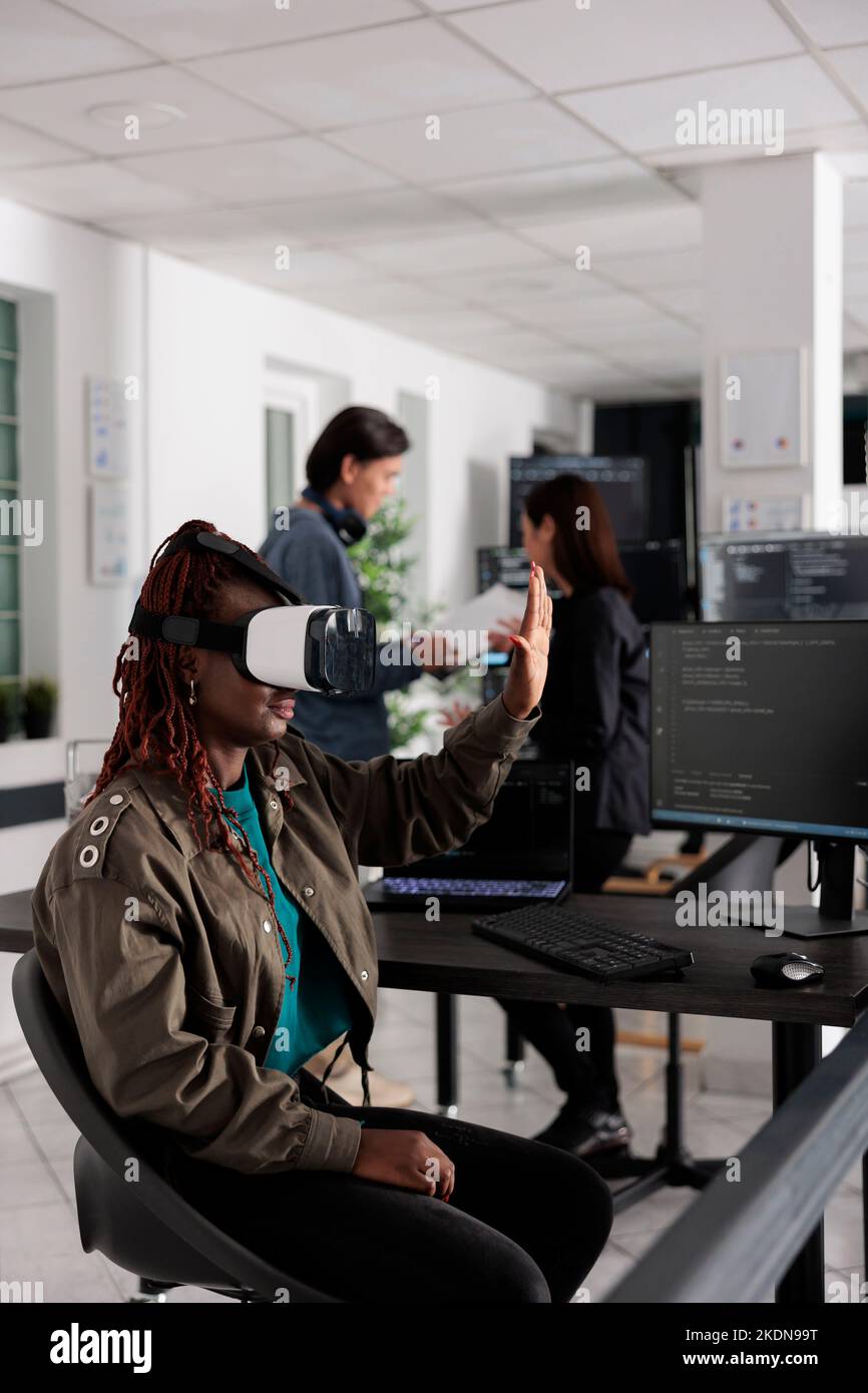 African american system engineer working with vr goggles to create programming server with html ...